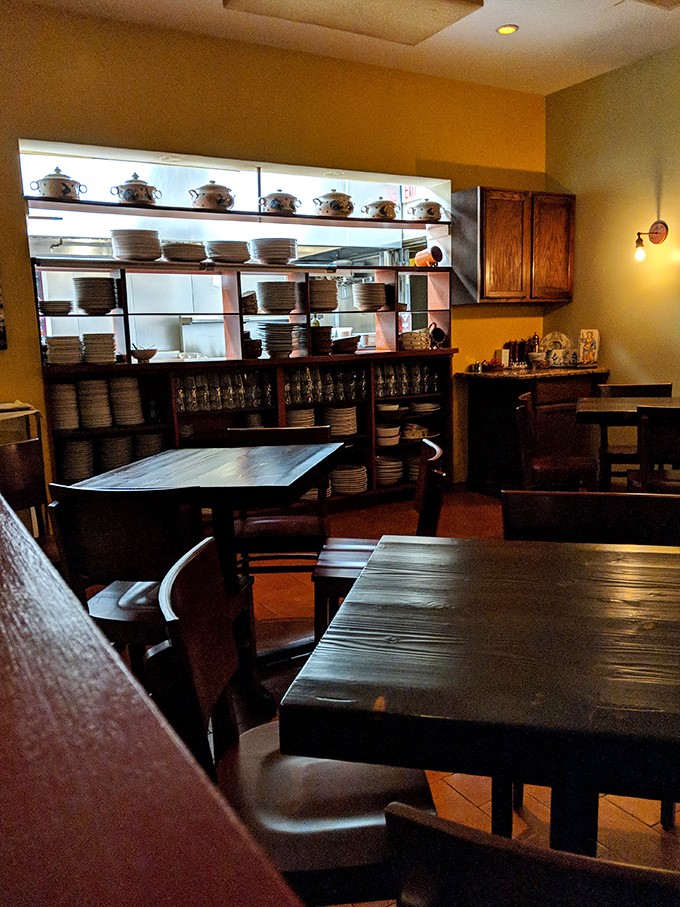 Warm amber walls, wooden tables, and shelves of traditional cookware create that perfect "nonna's kitchen" atmosphere. Rustic elegance that whispers rather than shouts.