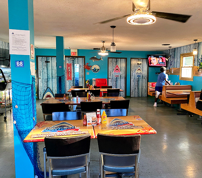 Inside, the nautical theme continues with turquoise walls and weathered wood accents. Even the restroom doors are guarded by sharks!