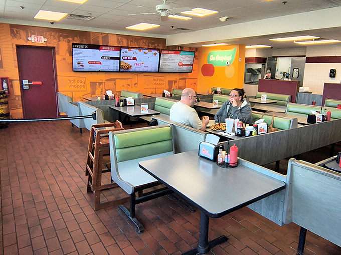 The interior speaks the universal language of comfort—orange walls, booth seating, and the gentle hum of satisfied conversation.