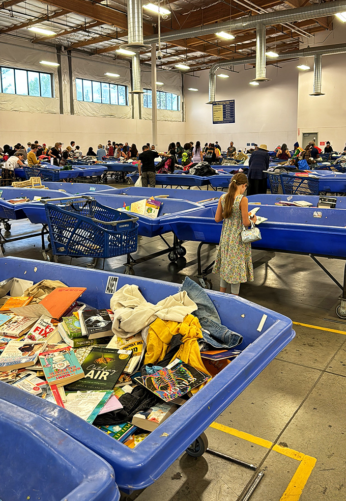 Welcome to the thrifting Olympics! Rows of blue bins stretch across the warehouse floor, each one a potential gold medal in waiting.