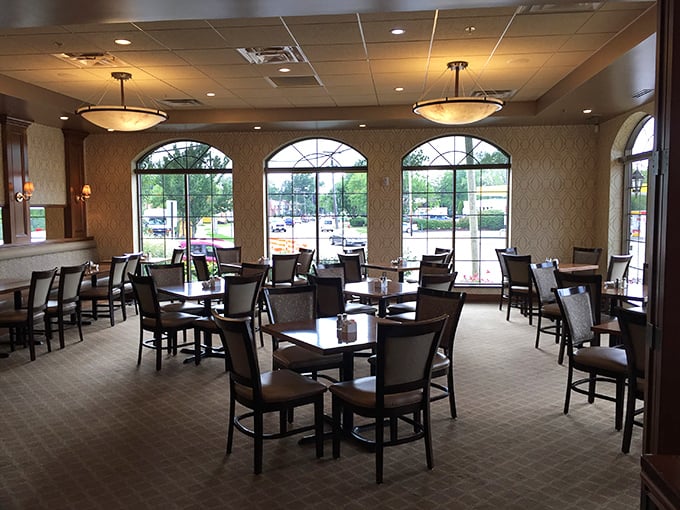 Sunlight streams through elegant arched windows, creating a dining room that balances upscale comfort with unpretentious charm. 