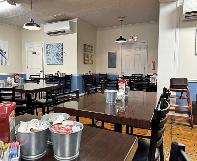 Inside, blue wainscoting meets wooden tables in a dining room that feels like the living room of that friend who actually knows how to cook.