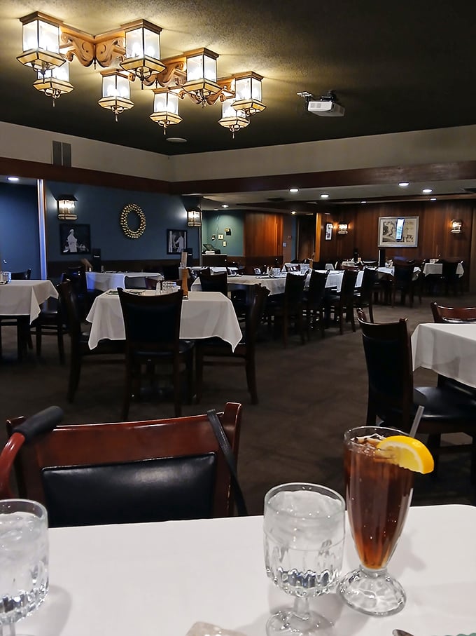 Elegant lighting fixtures cast a warm glow over crisp white tablecloths &ndash; dining ambiance that whispers "special occasion" without the pretension.