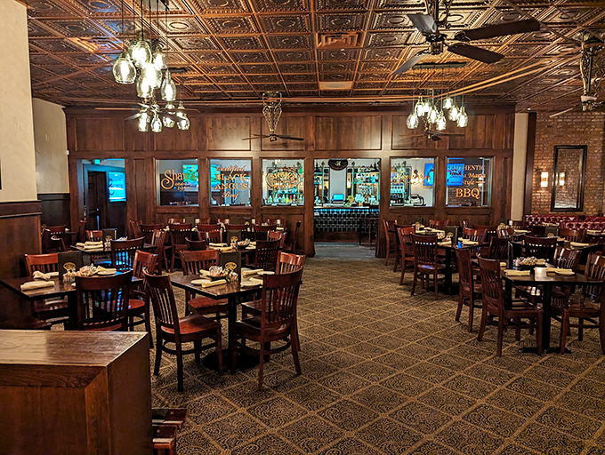 Copper ceiling tiles reflect warm light across dark wood furnishings, creating that rare atmosphere where conversations flow as smoothly as the cocktails.