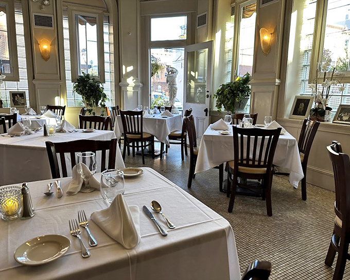 Step inside to a dining room where time stands still&mdash;pristine white tablecloths, elegant place settings, and sunlight streaming through tall windows create the perfect stage for culinary drama.