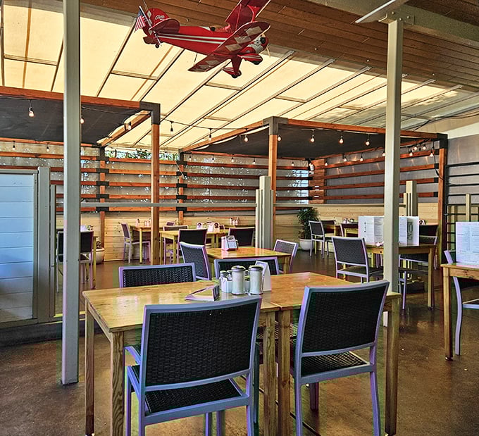 Modern industrial chic meets classic diner comfort, complete with suspended airplane dreams and exposed beam charm.