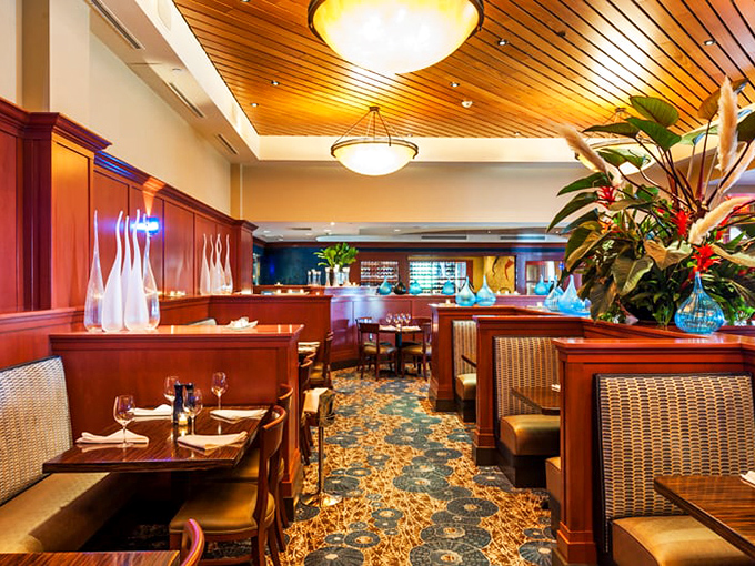 Polished wood ceilings, elegant lighting, and thoughtfully arranged seating create an atmosphere where comfort meets sophistication. Like a well-tailored suit for your dining experience.