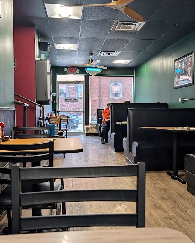 Classic diner aesthetics meet cozy comfort inside, where the green walls and dark booths create the perfect backdrop for life-changing comfort food encounters.