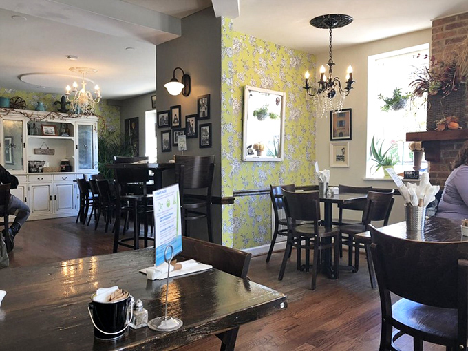 Vintage chandeliers, yellow floral wallpaper, and exposed brick create that rare atmosphere that's both sophisticated and cozy&mdash;like your stylish friend's dining room.