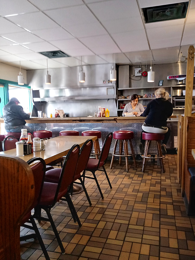Classic diner perfection: red vinyl stools, counter seating, and that unmistakable buzz of locals who've found their morning happy place.