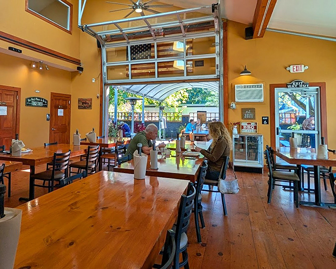 Sunshine yellow walls and garage-door openings create an airy, inviting space where serious BBQ business happens. The wooden tables practically beg for a platter of ribs.