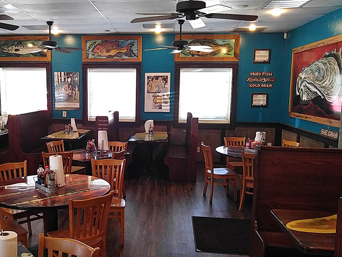 Vibrant turquoise walls adorned with colorful fish artwork create the perfect backdrop for seafood feasting. The dining room says "coastal casual" without shouting it.