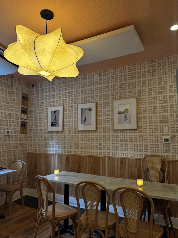 The star-shaped pendant light casts a warm glow over cane-backed chairs and patterned walls, creating that "I've discovered somewhere special" feeling.