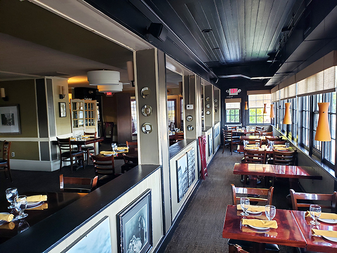 Sunlight streams through windows illuminating polished wood tables, where countless memorable meals have unfolded in this inviting dining space.