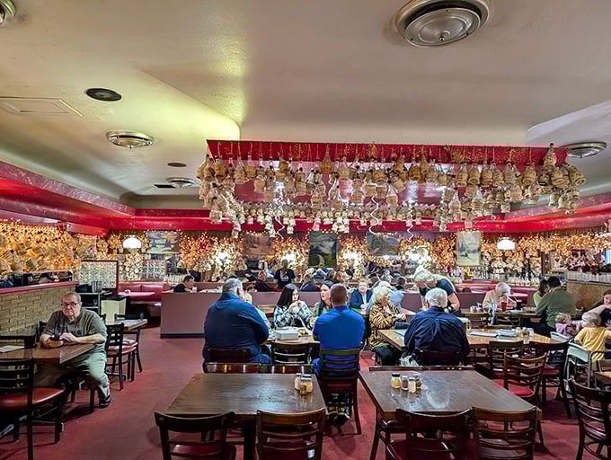 Hundreds of wax-dripped Chianti bottles hang from the ceiling like edible memories, each one representing a celebration where Detroit-style pizza took center stage.