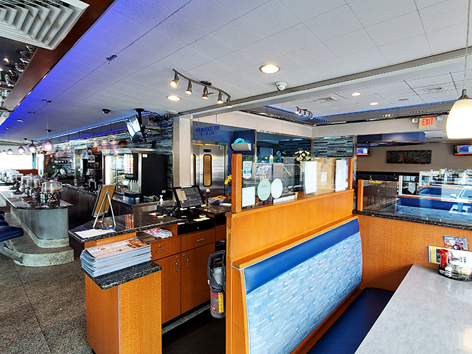 Step inside and breathe in that unmistakable diner aroma &ndash; coffee brewing, bacon sizzling, and conversations flowing across the classic blue and orange interior.