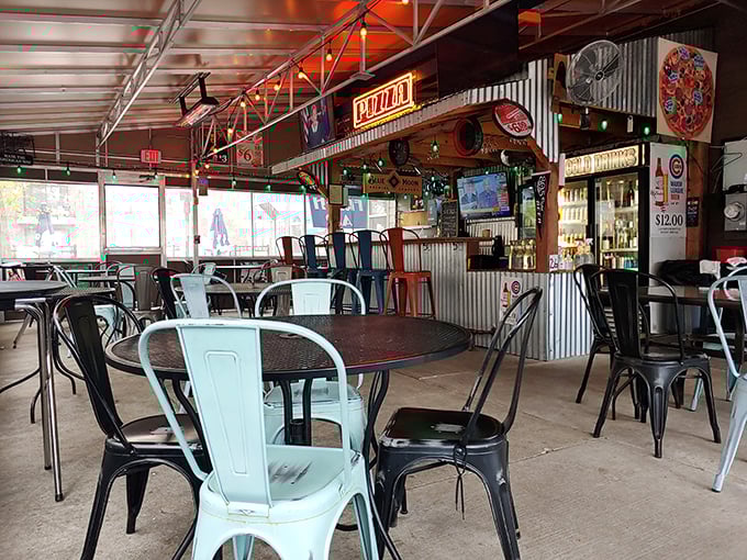 Industrial-chic meets pizza joint authenticity with metal chairs, simple tables, and corrugated walls creating the perfect backdrop for serious pizza business.