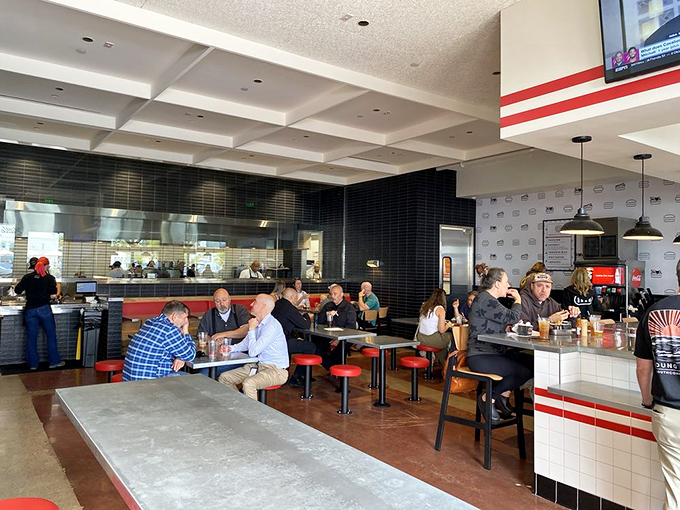 Modern minimalism meets burger paradise. The clean interior with its red accents and communal tables creates the perfect stage for the star of the show&mdash;the food.
