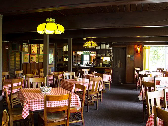 Classic red-checkered tablecloths and warm wood tones create that rare atmosphere where time slows down and conversations flow as freely as the gravy.
