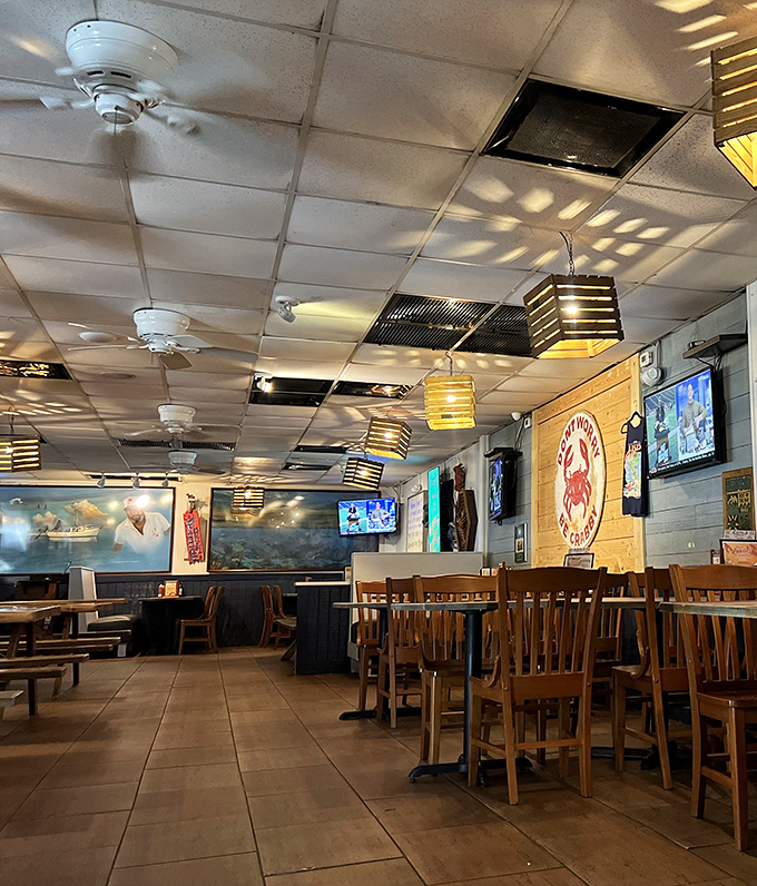 Inside, wooden chairs await beneath nautical-themed lighting fixtures, where ceiling fans lazily spin stories of countless seafood feasts past.