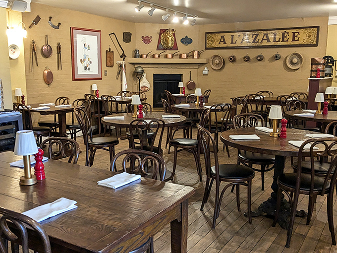 Bentwood chairs, copper cookware on butter-yellow walls, and the vintage "A L'AZALEE" sign create a dining room that feels like your favorite aunt's country home in Provence.