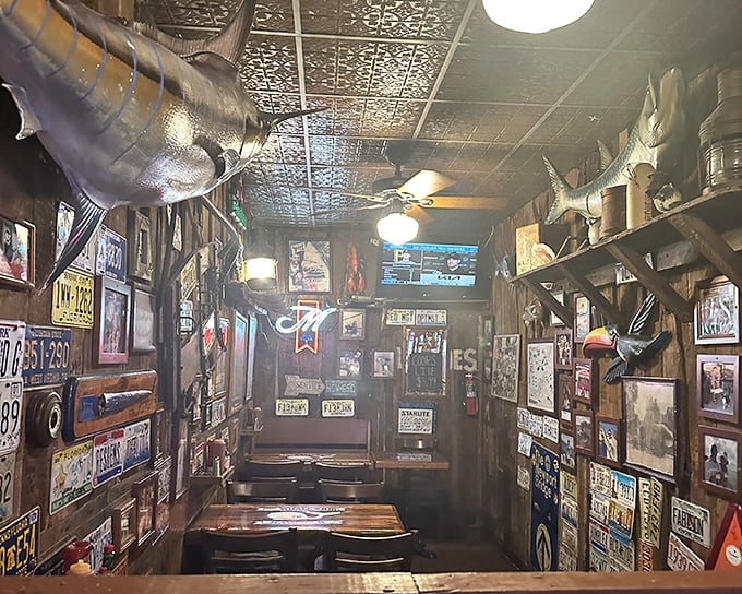 License plates from across America line walls where mounted fish keep watch. It's not decor&mdash;it's a visual diary of decades serving memorable meals.