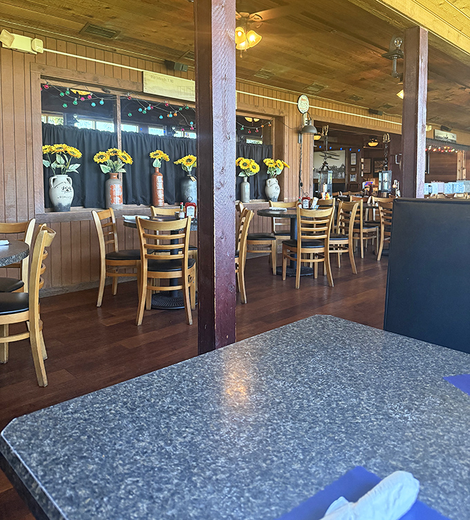 Sunshine streams through windows onto wooden paneling and cheerful yellow flowers, creating that "grandma's dining room meets Florida charm" ambiance.