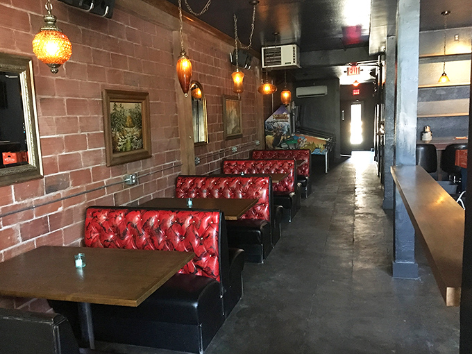 Those cherry-red tufted booths aren't just Instagram-worthy; they're the perfect perch for the serious business of burger appreciation against exposed brick warmth.