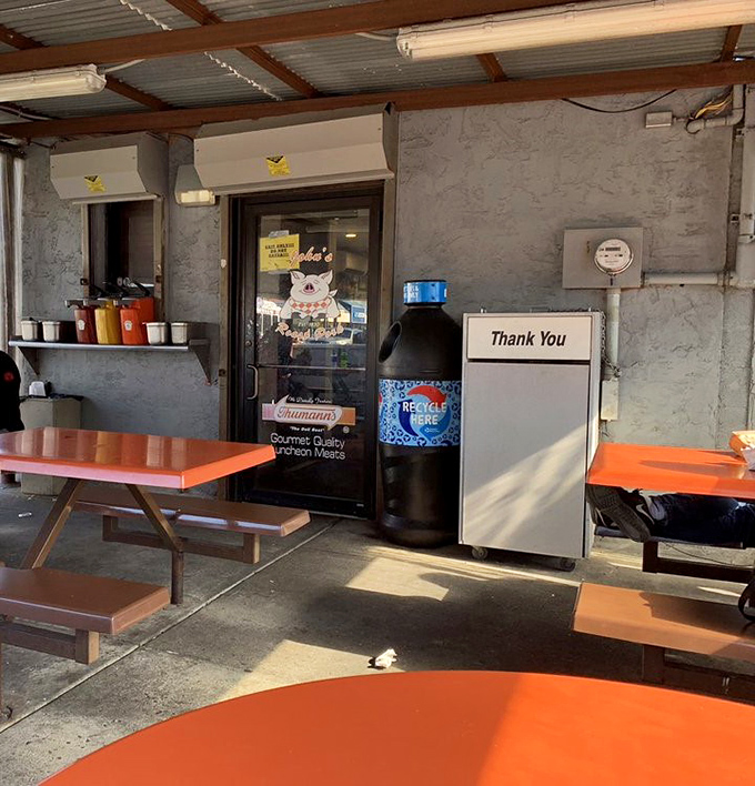 Simple orange tables under corrugated metal roofing prove that culinary greatness doesn't need fancy interior design.