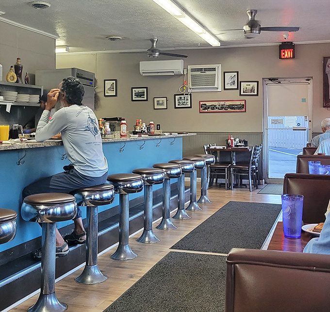 Classic chrome counter stools lined up like soldiers, ready for the breakfast brigade. This blue counter has witnessed more morning revelations than a therapist's couch.