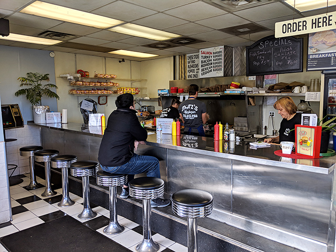 Classic Americana at its finest&mdash;chrome counter stools, checkered floor, and a front-row seat to the burger ballet. This is dinner theater for food lovers.