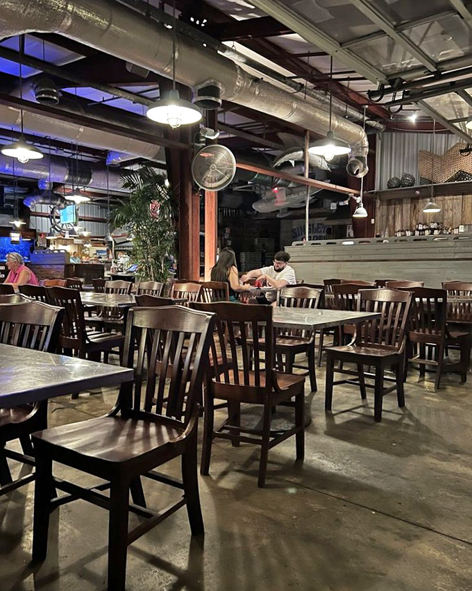 Industrial-chic meets maritime charm in this dining room where exposed ductwork and wooden accents create the perfect backdrop for seafood storytelling.