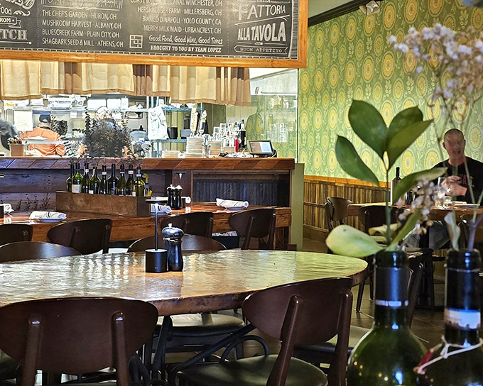 Vintage-inspired wallpaper meets wooden tables in a dining room that whispers, "Stay awhile," rather than shouting for Instagram attention.