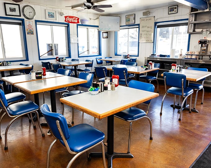 Classic blue vinyl chairs and formica tables create a time capsule of American diner culture where conversations flow as freely as the coffee.