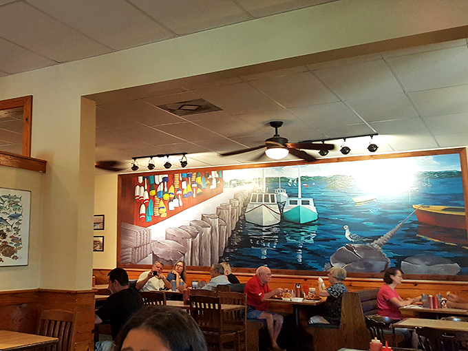 Wooden tables beneath a vibrant harbor mural transport diners straight to coastal Massachusetts. The ocean views come free with every meal.