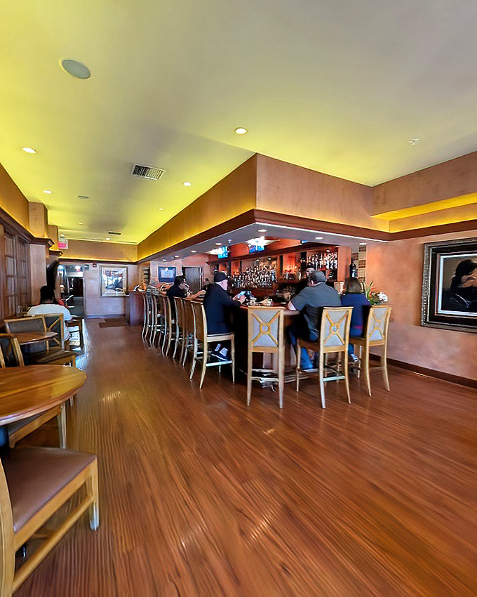 The warm wood and amber lighting of Hap's bar area creates that magical steakhouse glow where everyone looks like they've made excellent life choices.