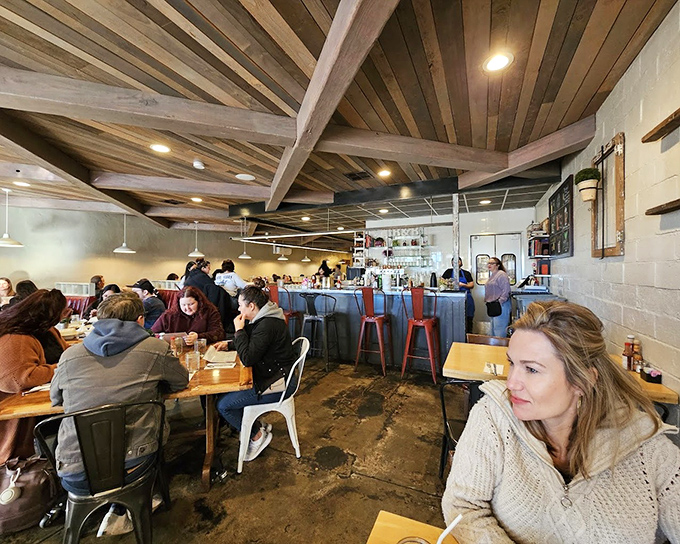 Warm wooden ceiling beams and industrial-chic design create the perfect backdrop for breakfast bliss. The bustling interior hums with satisfied diners plotting their next visit.