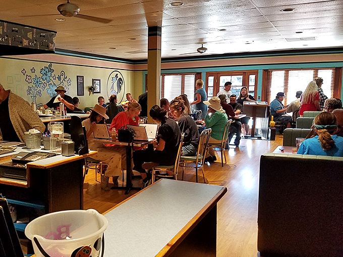 The bustling interior where strangers become neighbors. Wooden floors, colorful walls, and the hum of conversation create Ojai's living room.