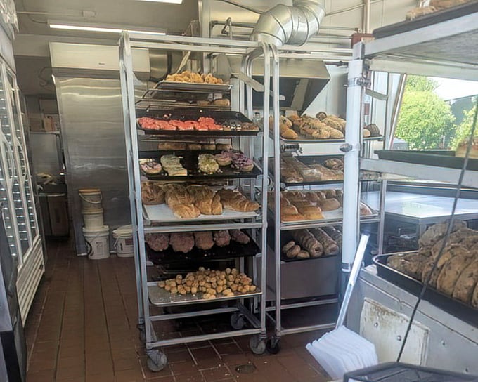 Behind the scenes, racks of freshly made donuts await their destiny. This is where donut dreams are born, one tray at a time.
