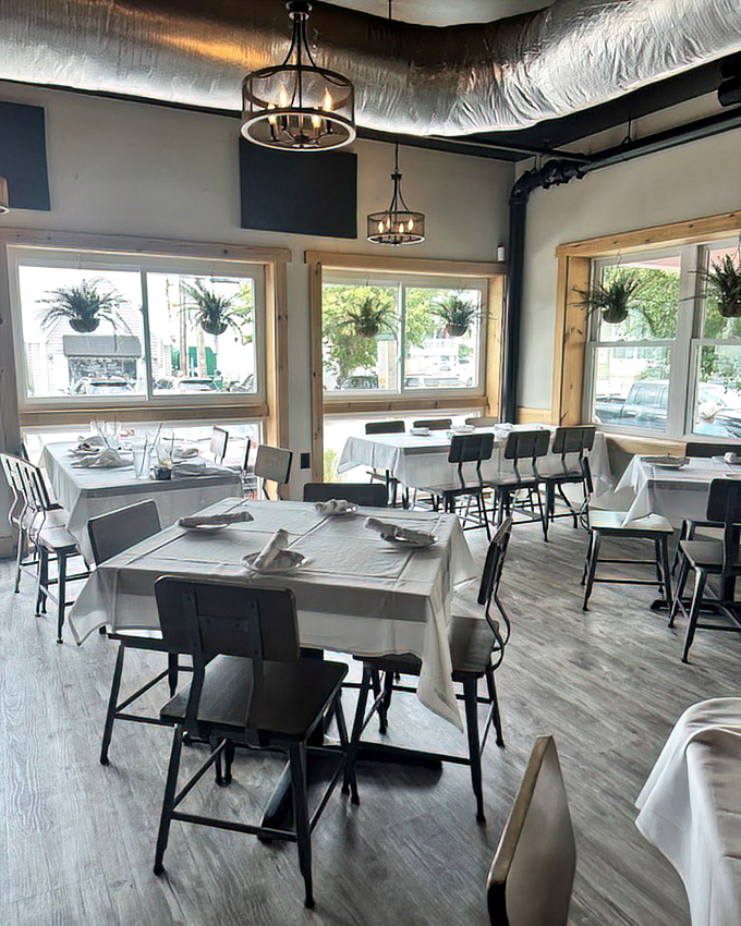 Simple elegance defines the dining room, where hanging plants and natural light create an atmosphere that lets the vibrant food take center stage.