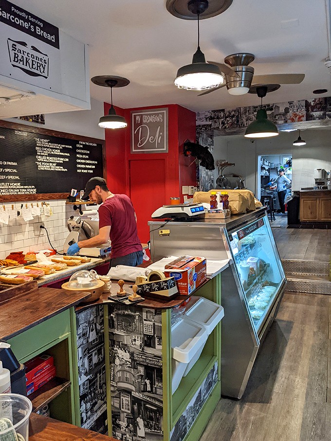 Where sandwich artistry happens. The red accent wall and vintage Philly photos aren't just decor &ndash; they're a visual appetizer before the main event.