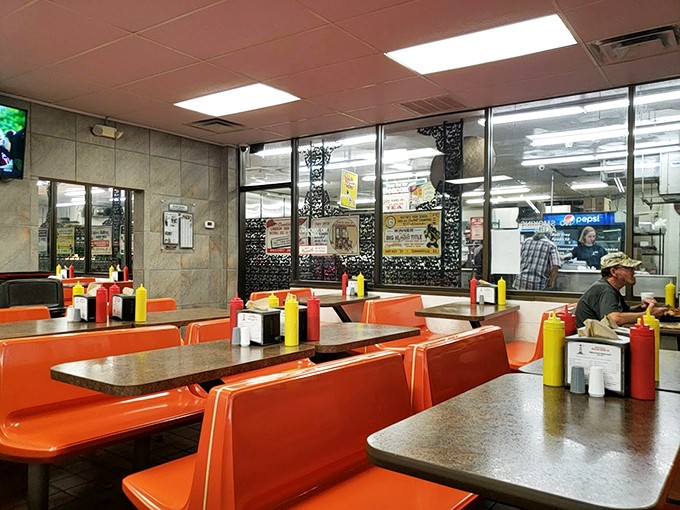 Orange booths and condiment-lined tables create the perfect backdrop for the food drama about to unfold on your plate.