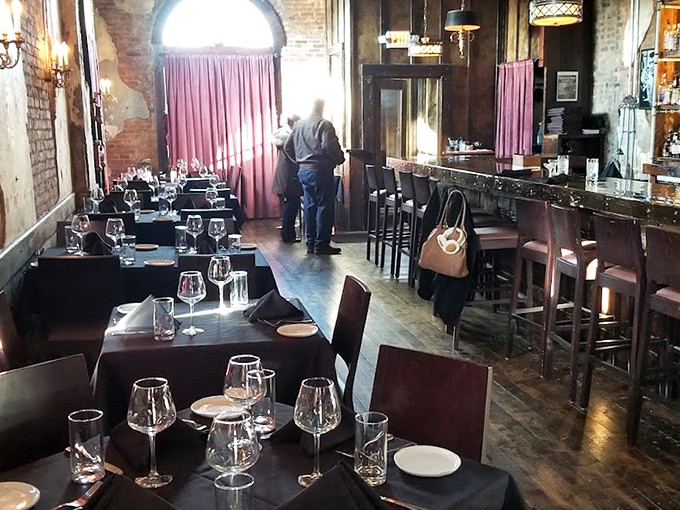 Step inside to discover the perfect marriage of rustic charm and elegant dining&mdash;exposed brick walls, pink curtains, and tables set for memorable meals.