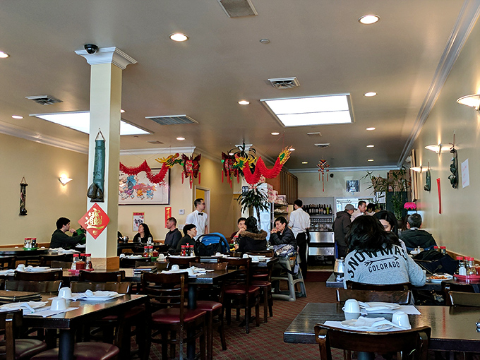 The bustling interior where magic happens. Traditional Chinese decorations hang from the ceiling while diners focus on what really matters &ndash; those legendary plates.