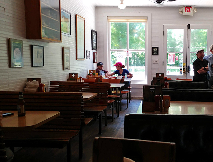 Wooden booths worn smooth by countless satisfied diners tell stories of memorable meals past. Sunlight streams through windows framing Kentucky's rolling hills beyond.
