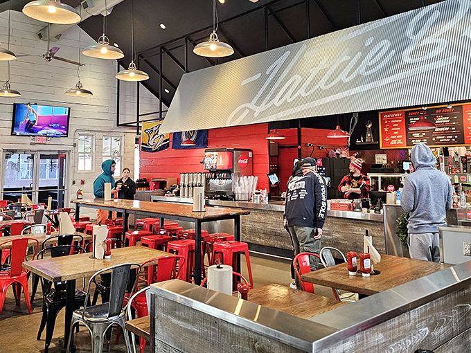 Industrial-chic meets Southern hospitality inside, where red metal chairs and wooden tables create the perfect backdrop for the flavor drama about to unfold.