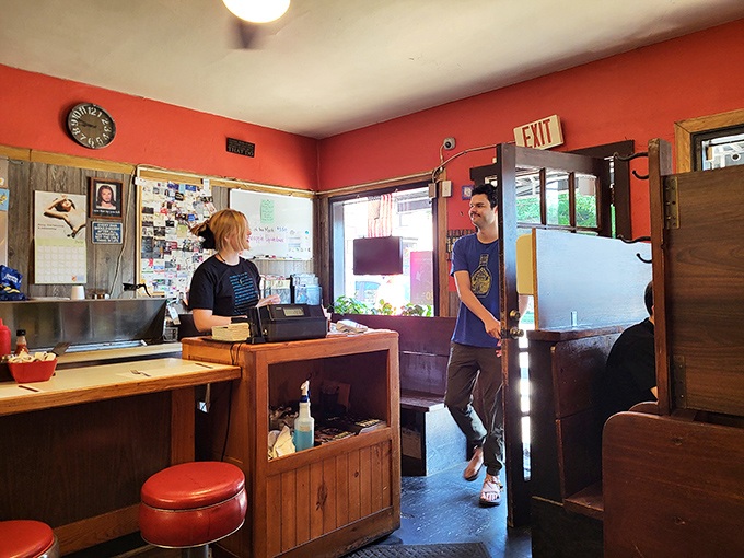 Inside, coral walls and wooden accents create that perfect diner atmosphere where conversations flow as freely as the coffee. 