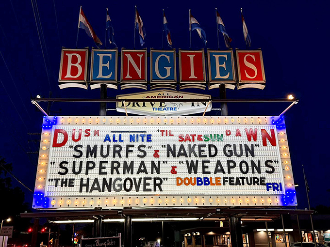 The marquee doesn't just announce movies&mdash;it broadcasts nostalgia in red, white, and blue neon. Cinema history illuminated against the night sky.