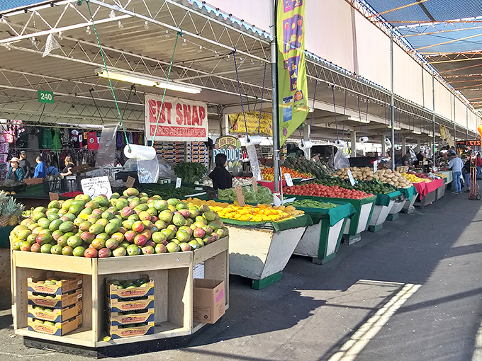 Nature's bounty on display! Mangos, tomatoes, and citrus fruits create a vibrant color palette that makes even the most dedicated digital shopper remember the joy of market browsing.