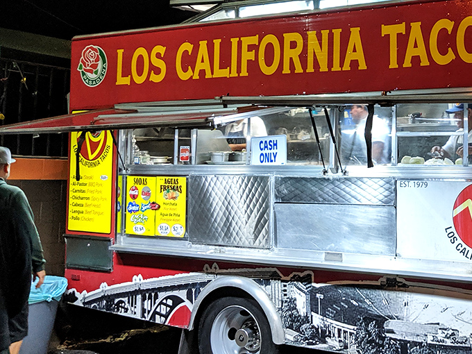 Night falls, but the taco hunt continues as hungry patrons gather at the illuminated service window, where culinary magic happens in plain sight.
